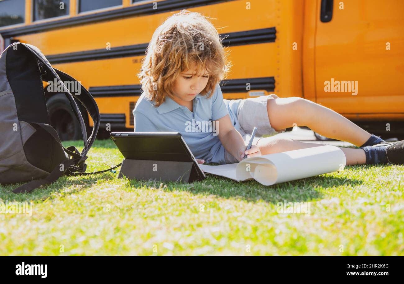 Pupil writing homework with tablet in school park. Distance learning ...