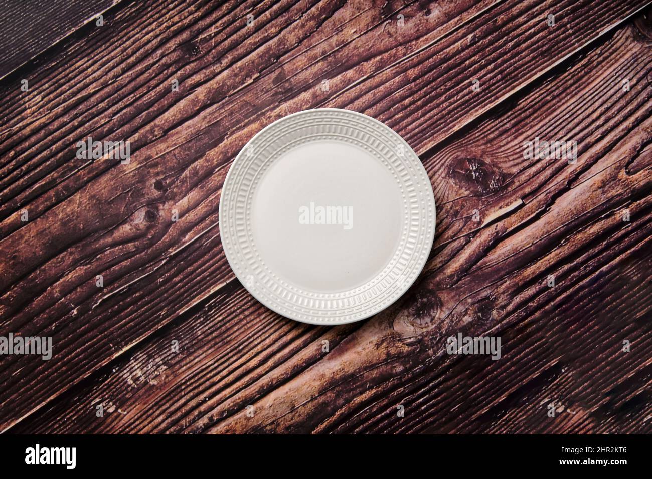 A small white plate with a circular dimple dash pattern against a ...