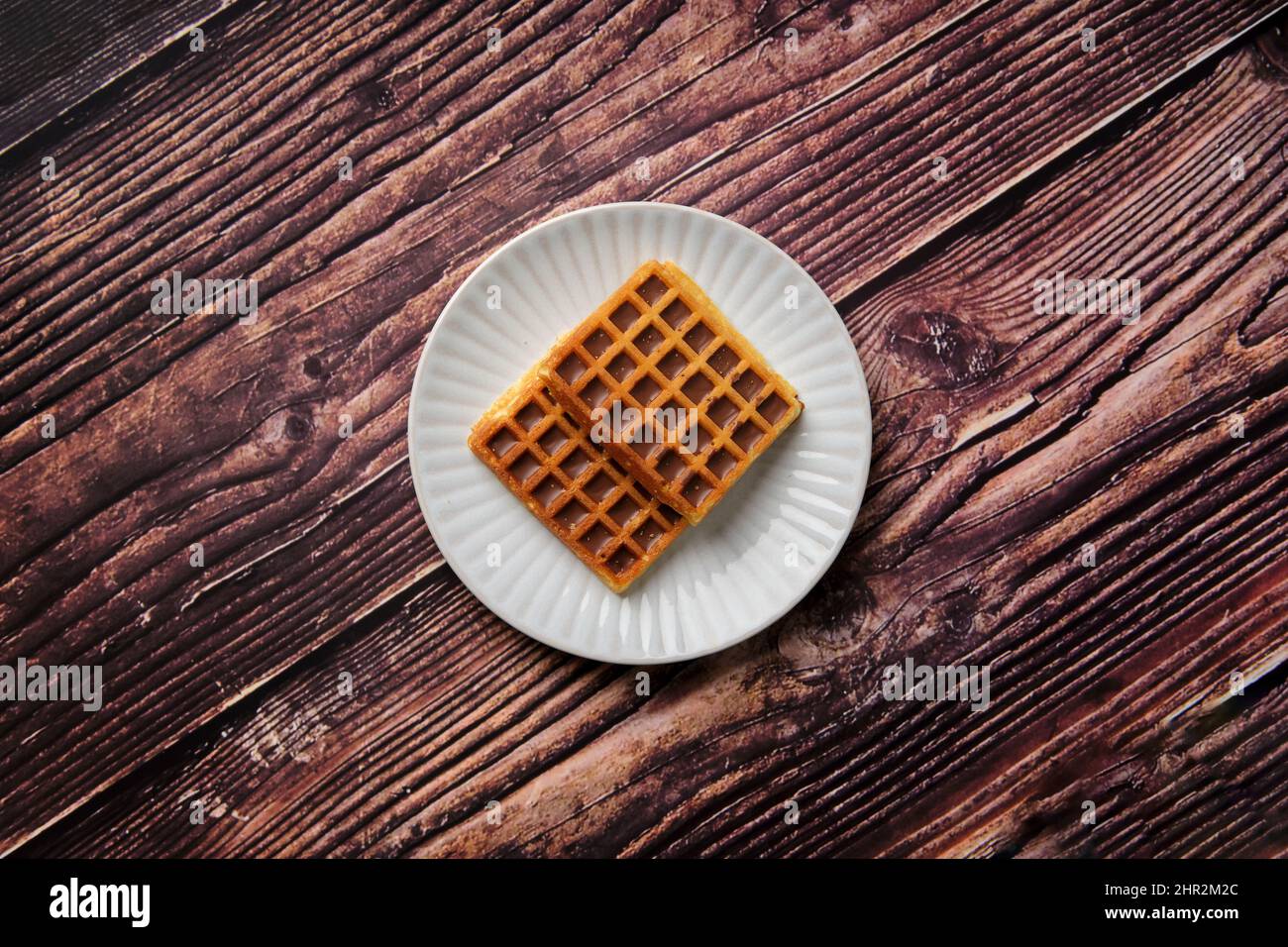Chocolate & hazelnut flavour waffles from above on a wooden background ...