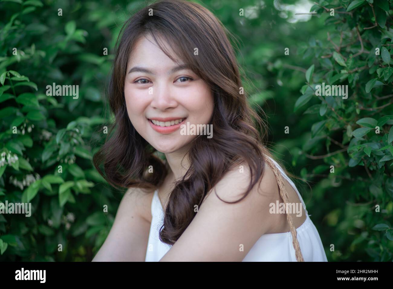 Portrait of smiling beautiful asian women in park morning light with bokeh half body portrait ...