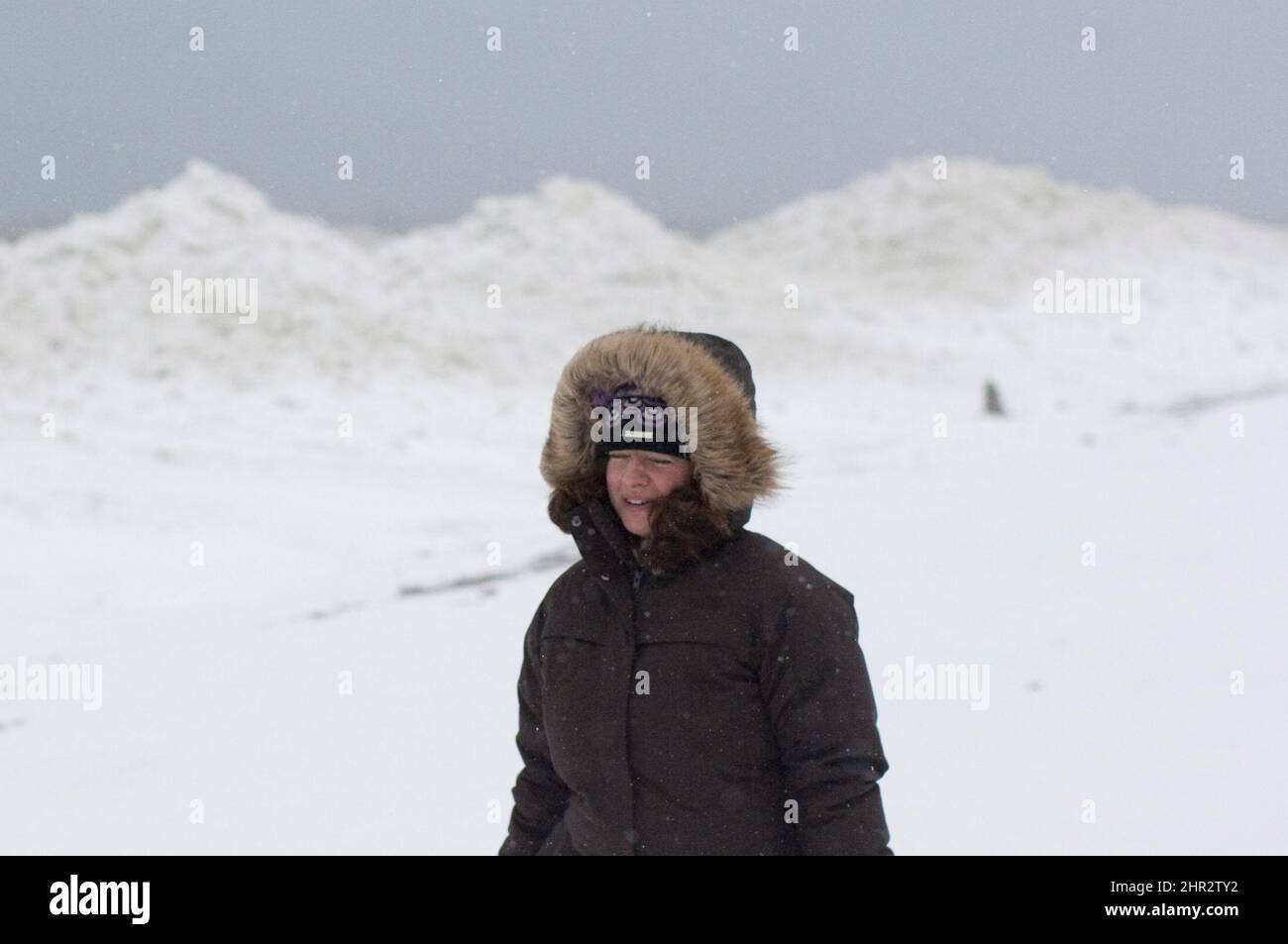 A woman walks along the lakeshore in Toronto as a winter snow storm ...