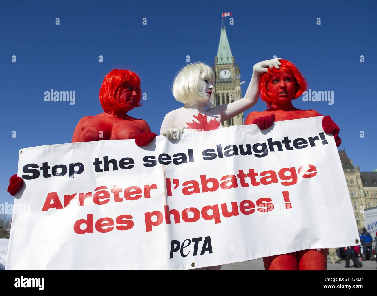 A group of three female PETA protesters wear a layer of paint as they ...