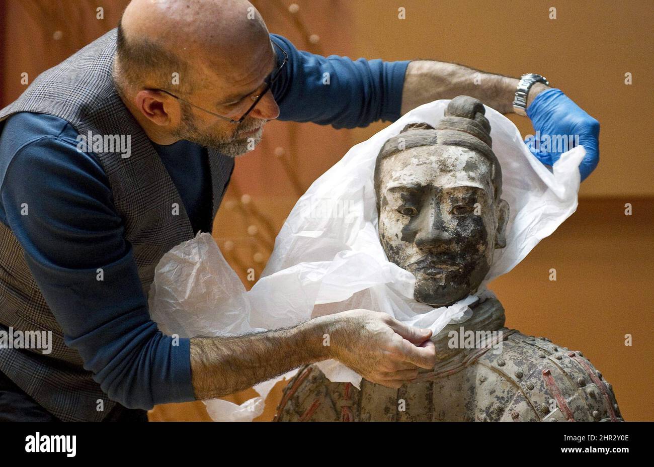 Richard Gagne uncrates a statue representing a kneeling archer as part ...