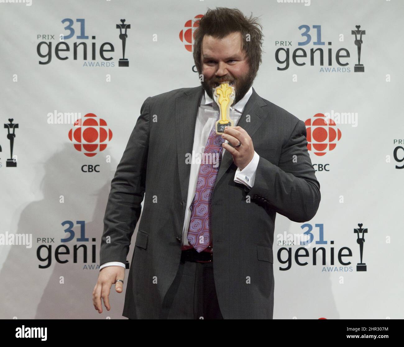 Tyler Labine clowns around with a cookie shaped like a Genie Award as ...