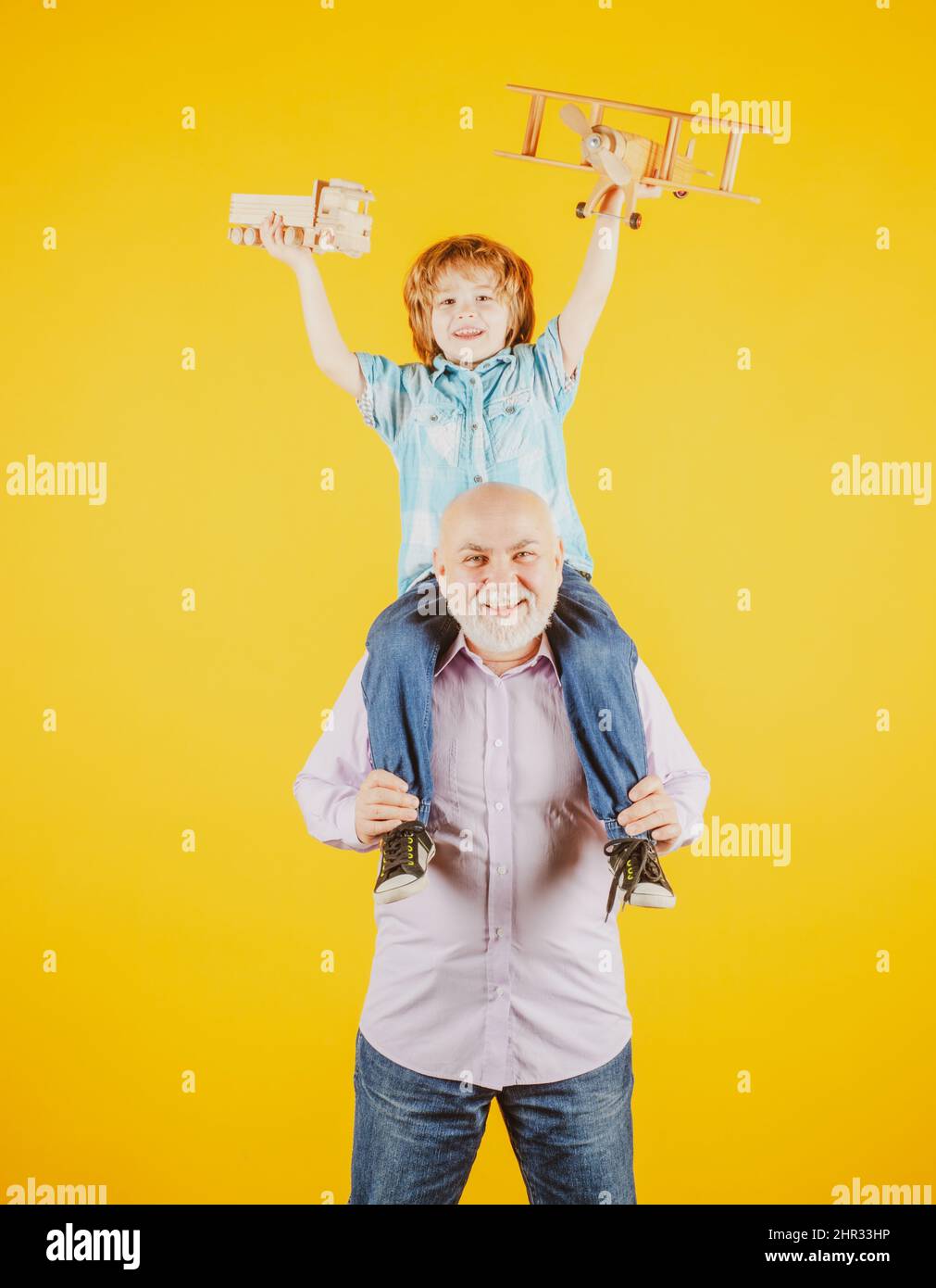 Old grandfather and young child grandson with toy plane and wooden toy ...