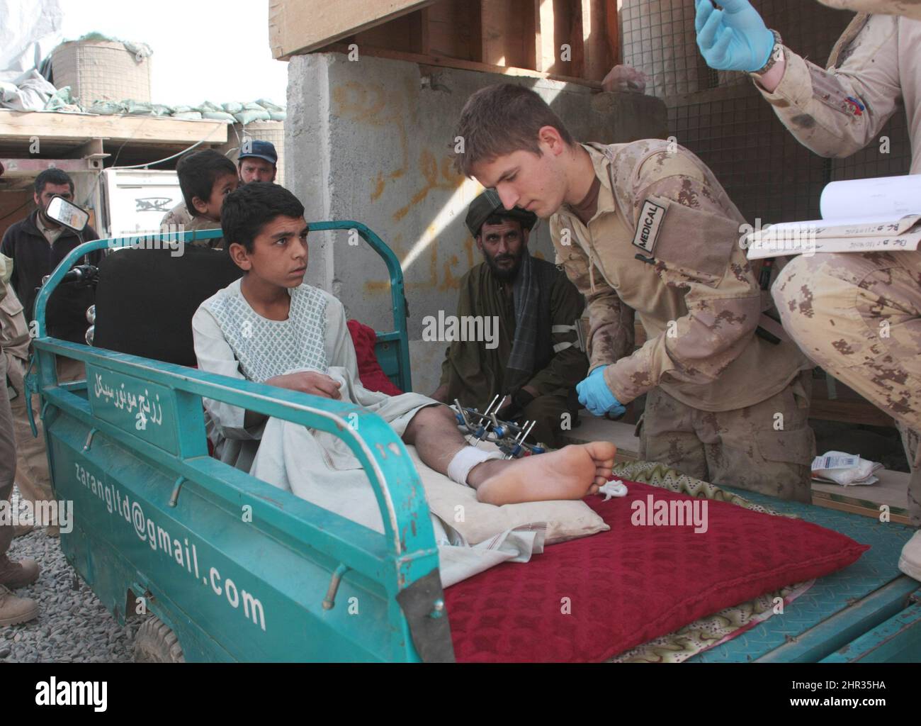 Canadian Cpl. Maxime Robichaud-Bolduc tends to an Afghan boy as his ...