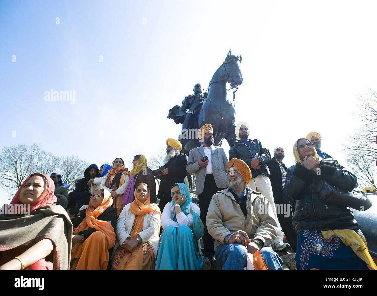 A group of Sikhs stand around a statue of Kind Edward VII, which ...