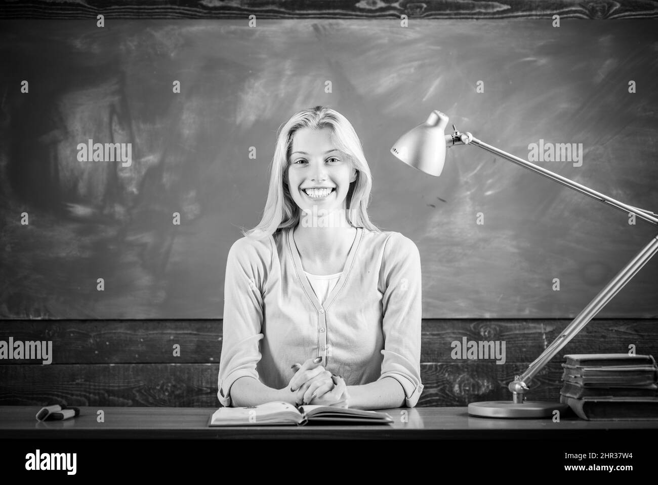 The teacher in the classroom on blackboard background. Teaching and ...