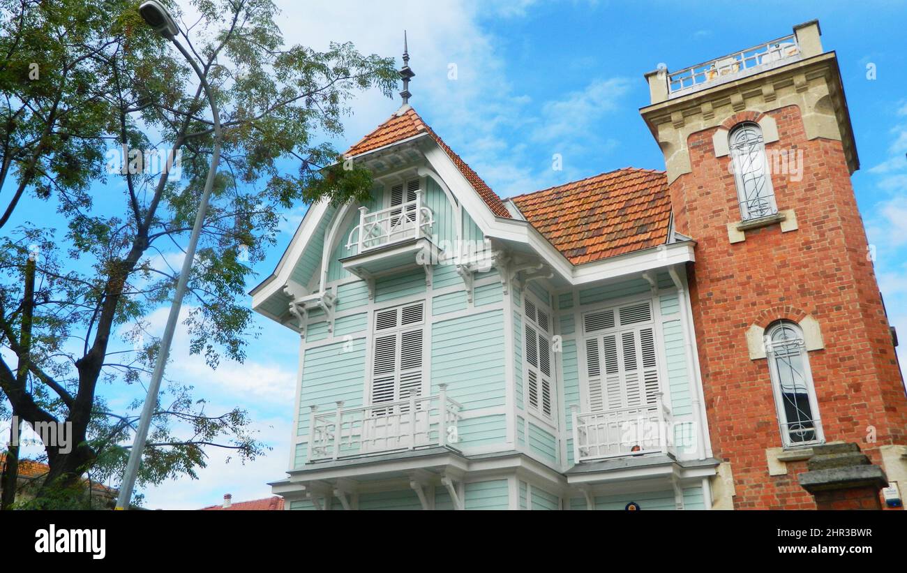 white, wood, gable roof house. small balcony, big windows surrounding ...