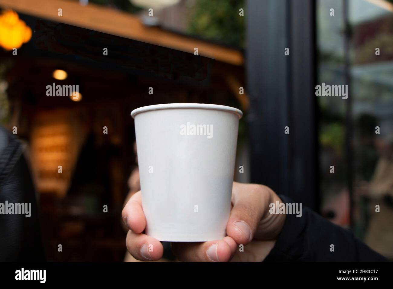 a man holding his hand a white plastic cup. He shows the cup with no ...
