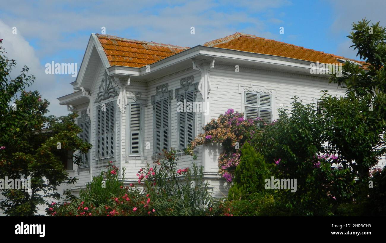 white, wood, gable roof house. small balcony, big windows surrounding ...