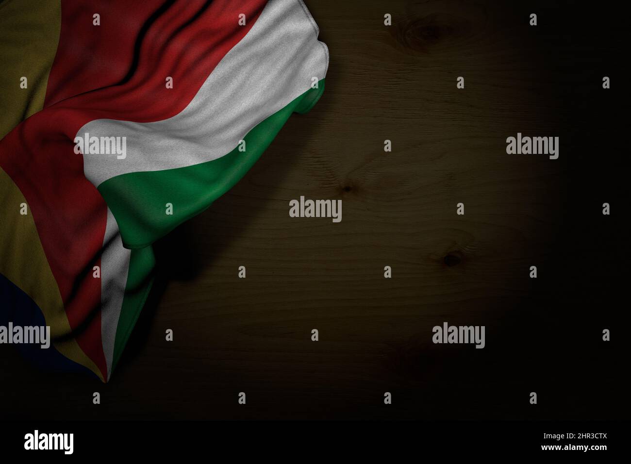 pretty dark picture of Seychelles flag with large folds on dark wood ...