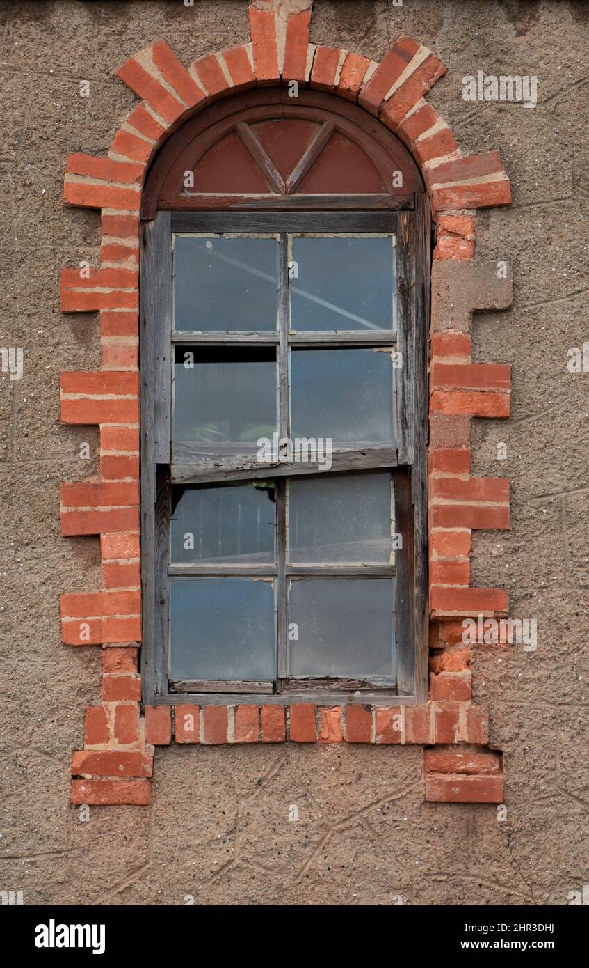 Old, tumbledown christian window surrounding red brick edges Stock ...