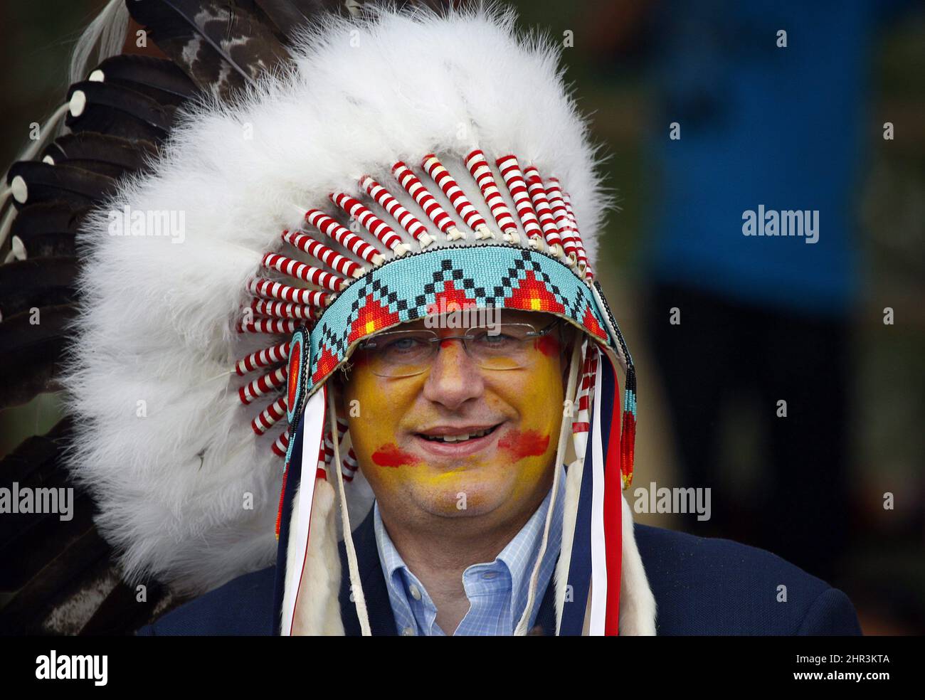 Prime Minister Stephen Harper wears a headdress after being made an ...