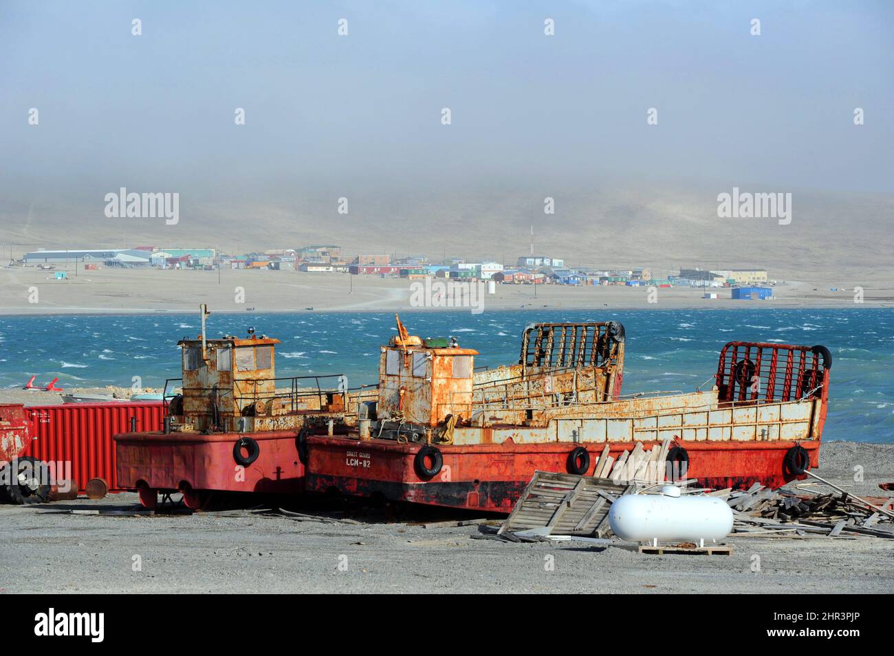 The Hamlet of Resolute Bay is seen beyond two barges on the shore of ...