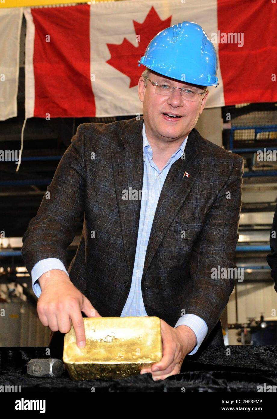 Prime Minister Stephen Harper holds a $1.8-million bar of gold as he ...