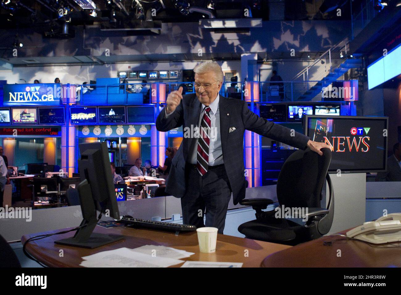 CTV news anchor Lloyd Robertson gestures to producers as he takes his ...