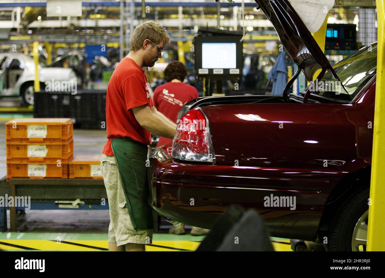 Factory employees work on Ford Crown Victoria vehicles on Thursday ...