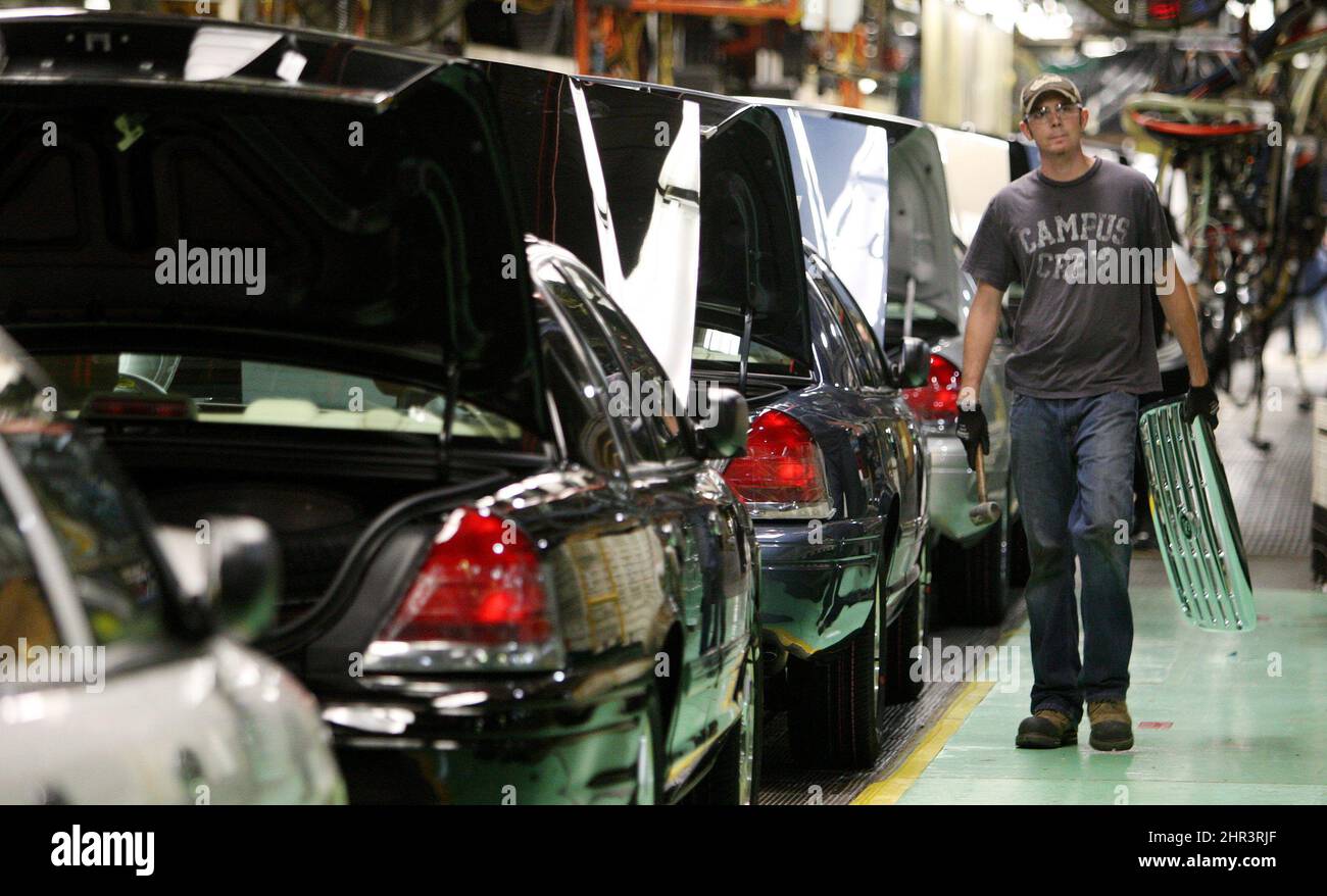 Factory employees work on Ford Crown Victoria vehicles on Thursday ...