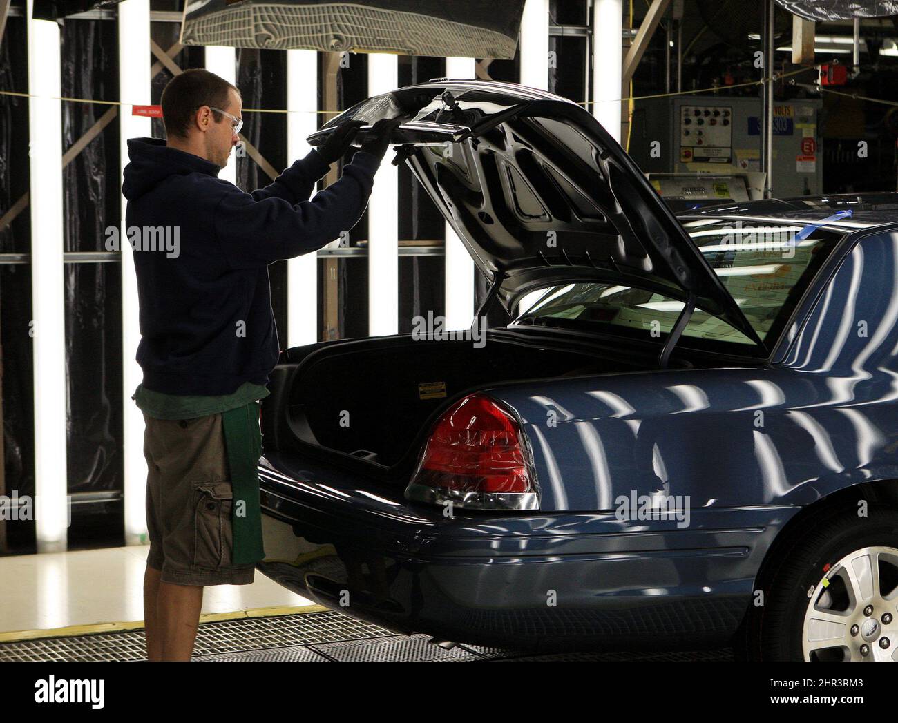 Factory employees work on Ford Crown Victoria vehicles on Thursday ...
