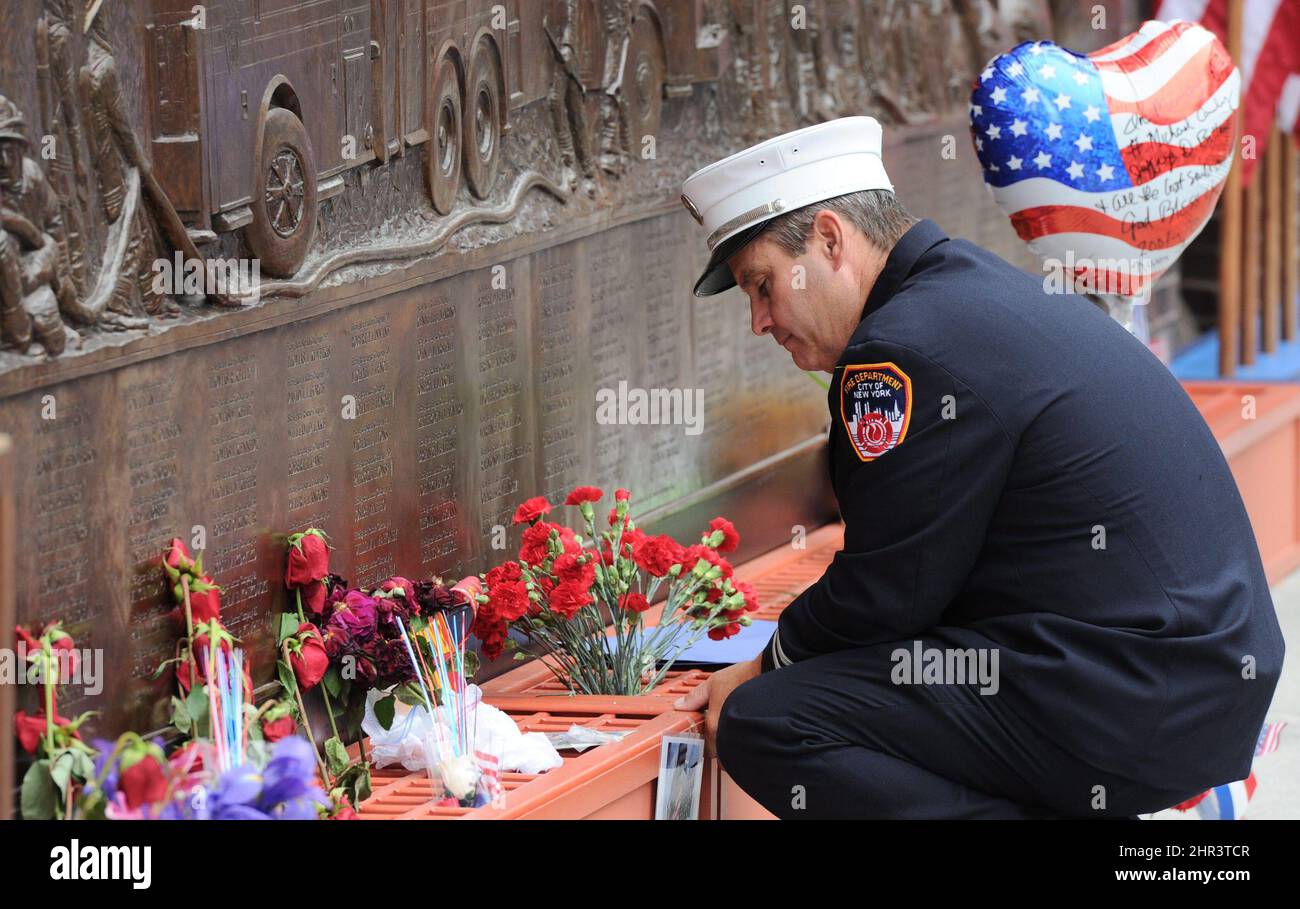 A New York city firefighter pauses the firefighters memorial wall that ...