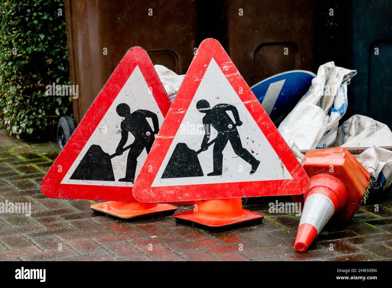 Men at Work signs, traffic cones and signage in domestic garden Stock ...