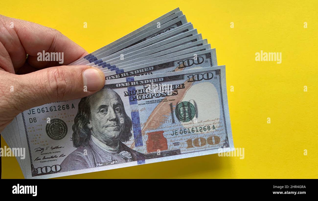Hand holding model US bank note with yellow background Stock Photo - Alamy