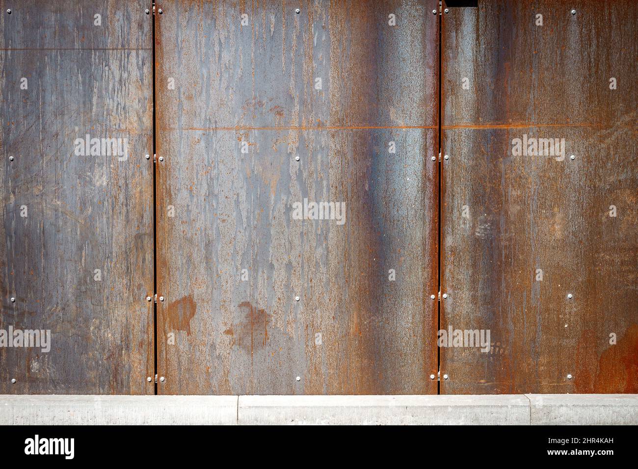 Modern architecture rusty metal wall and a sidewalk Stock Photo - Alamy