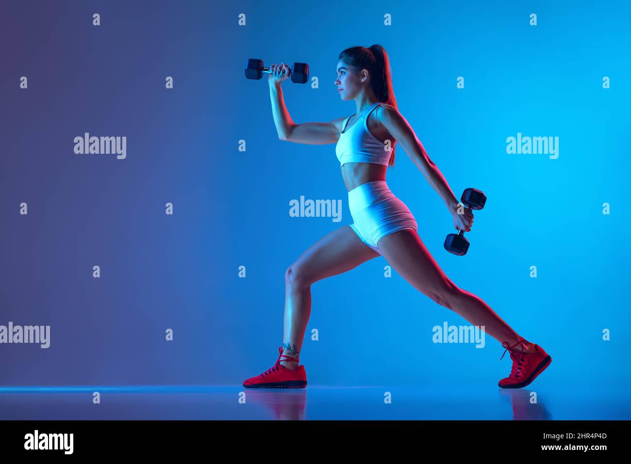 Young sportive girl training with sports equipment isolated on gradient ...