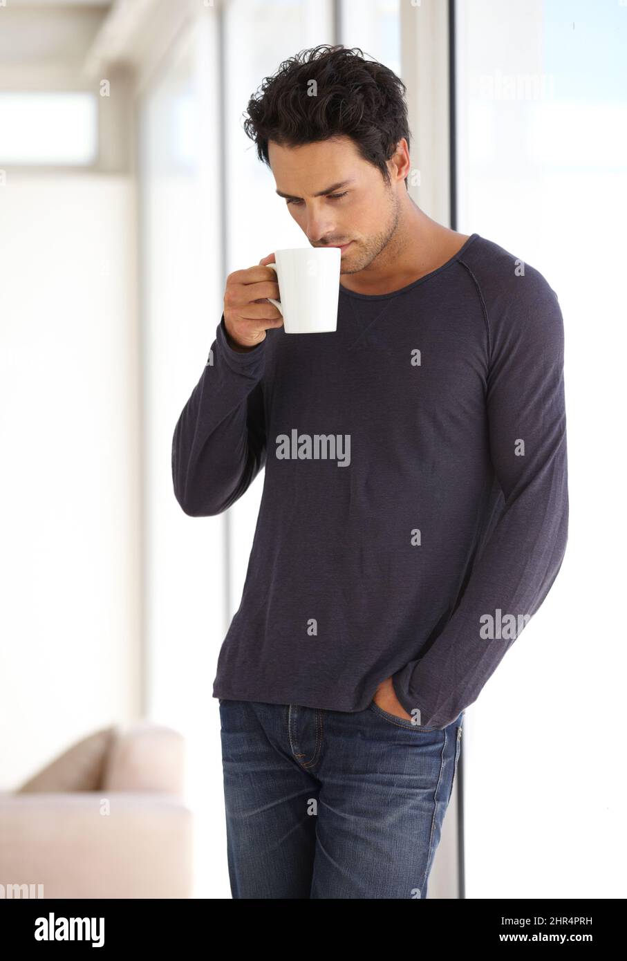 The first sip. A handsome young man sipping his morning coffee Stock ...