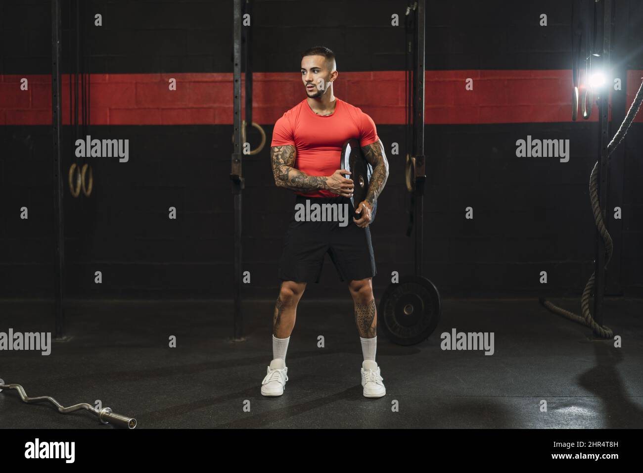 Athlete posing in the gym in a red workout shirt Stock Photo - Alamy
