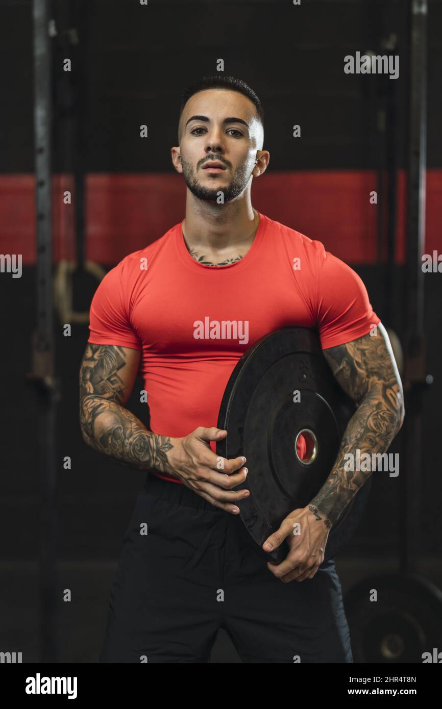 Shot of an athlete posing in the gym in a red workout shirt Stock Photo ...