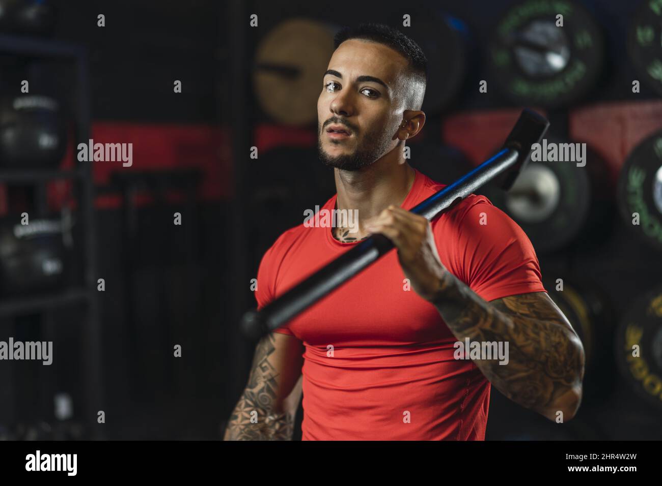 Strong muscular European guy with cool tattoos working out in a gym ...