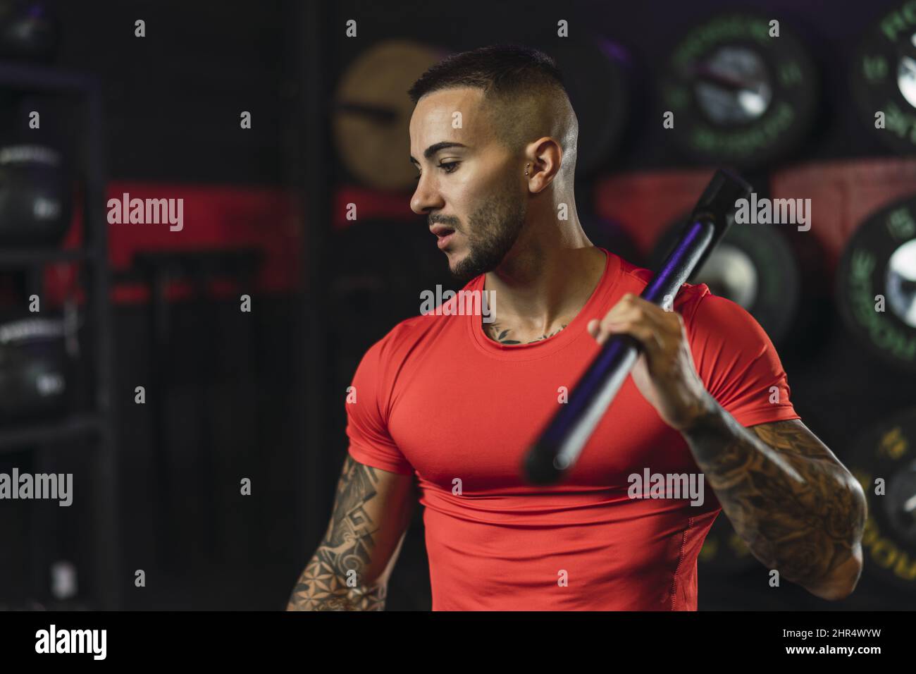 Strong muscular European guy with cool tattoos working out in a gym ...