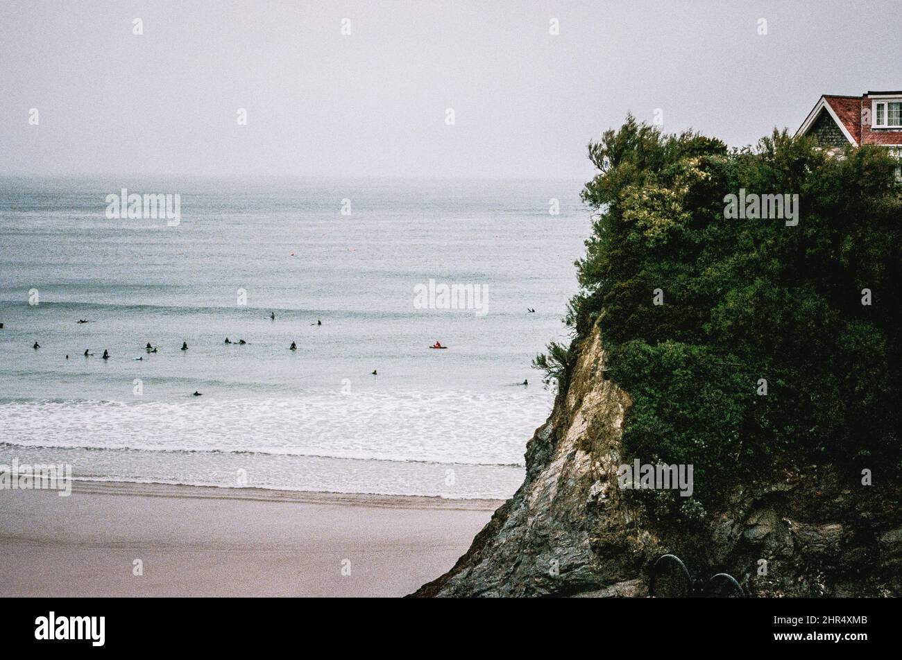 Beautiful sandy beach with people swimming on a gloomy day Stock Photo ...