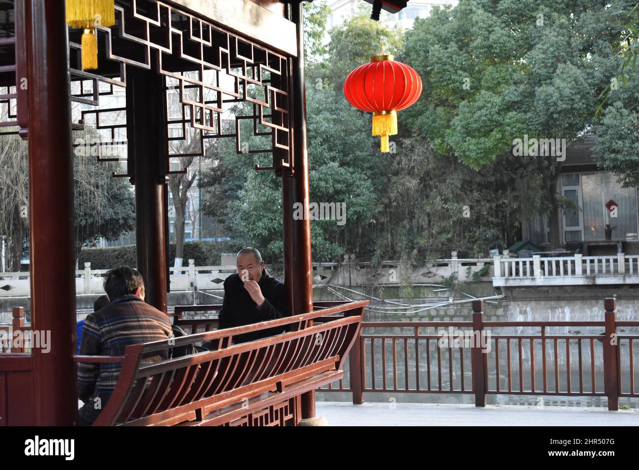 A view of people sitting in a typical Asian alcove in the park in ...