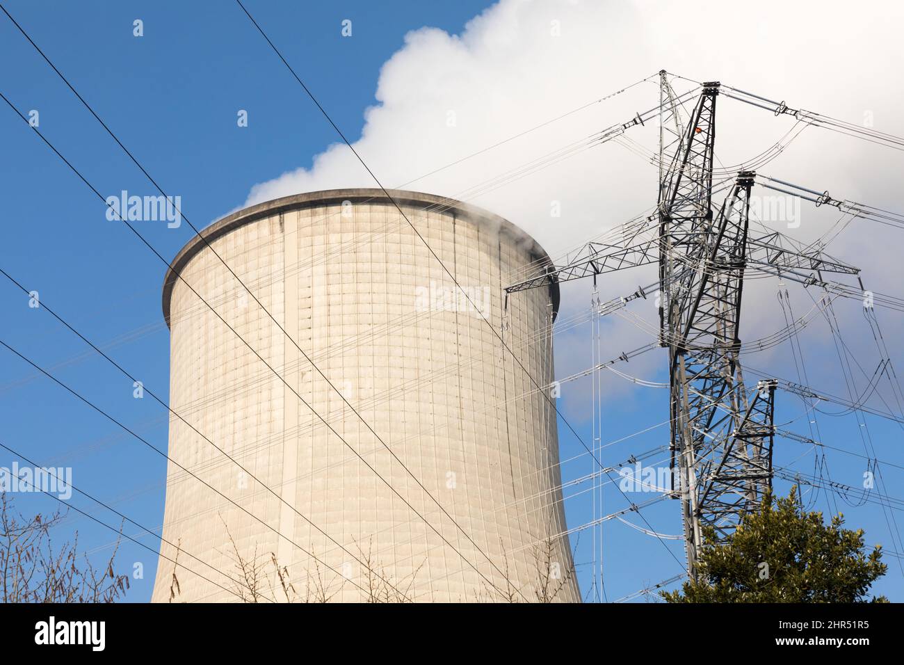 Cooling tower of nuclear power station near a transmission post against ...