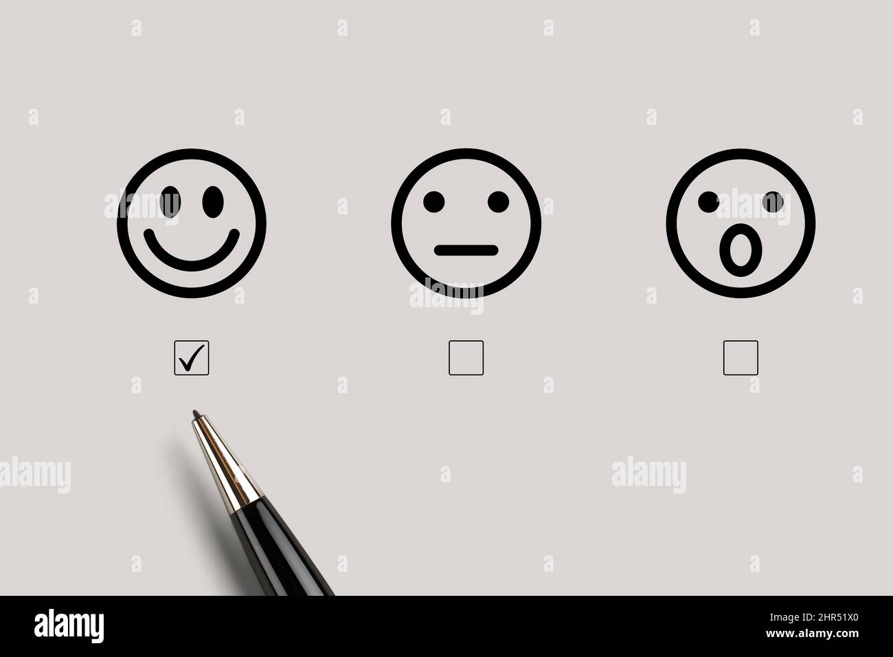 Pen on a background of a sheet with a tick mark under a smiley face ...