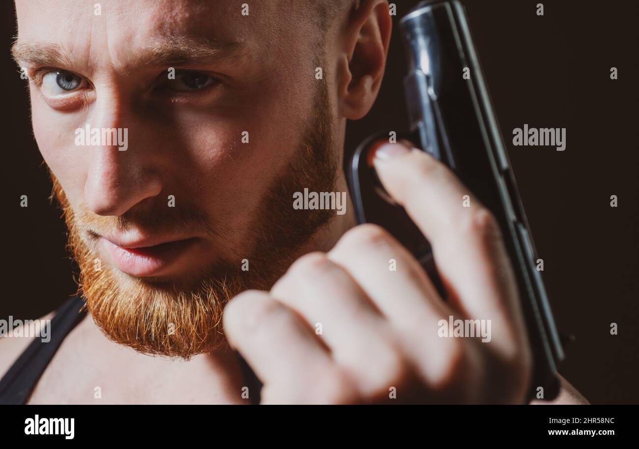 Gangster in action, killer aiming pistol gun. Close up portrait of guy ...