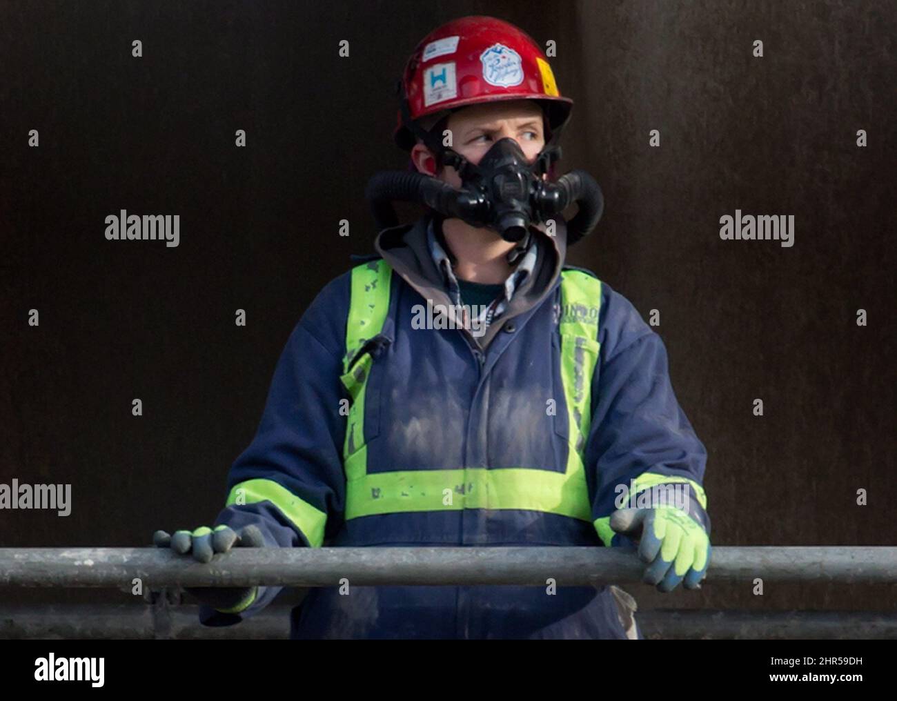 A worker wears a breathing apparatus while erecting scaffolding at Teck ...