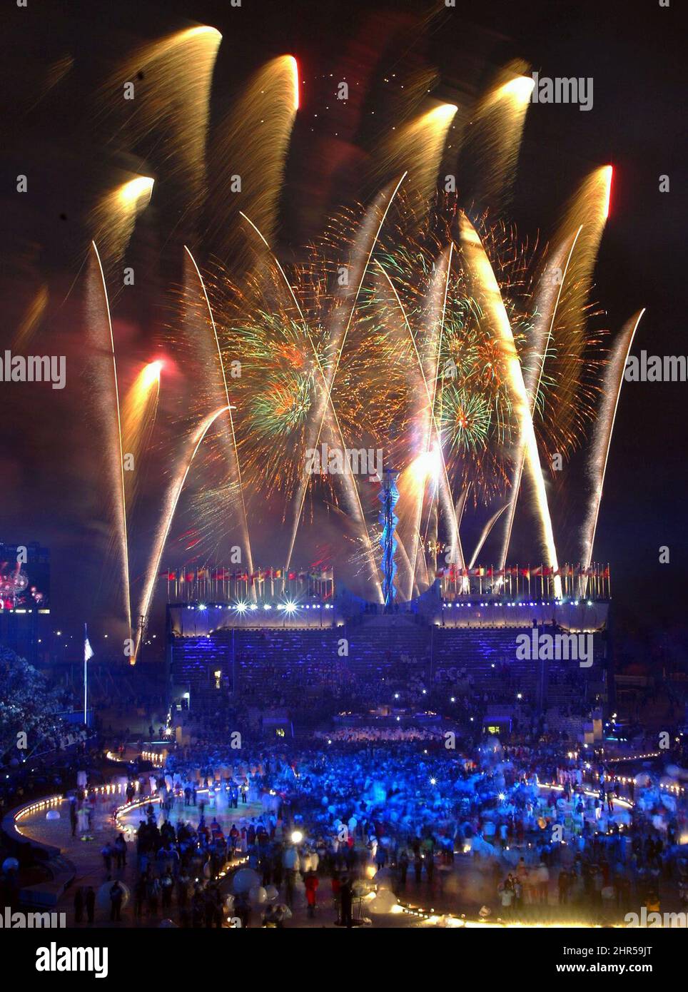 PA PHOTOS/CP - UK USE ONLY: Fireworks burst over athletes milling ...