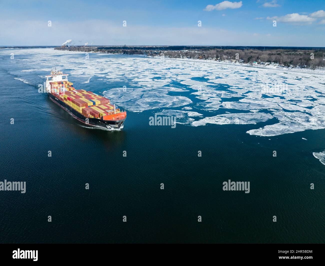 Aerial view of a container ship going upstream through winter ice in ...