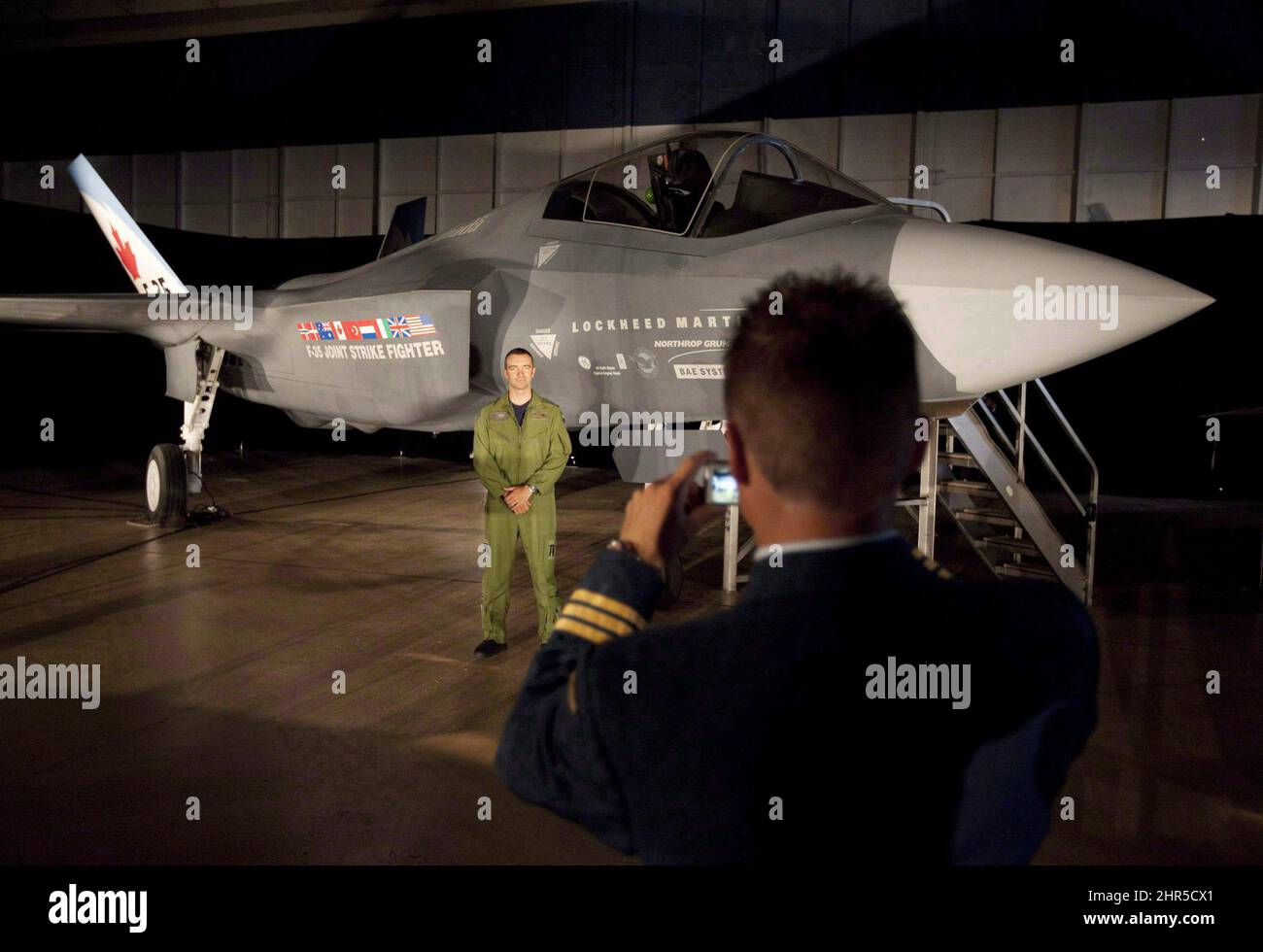 A Canadian Forces pilot has his picture taken in front of a F-35 Strike ...
