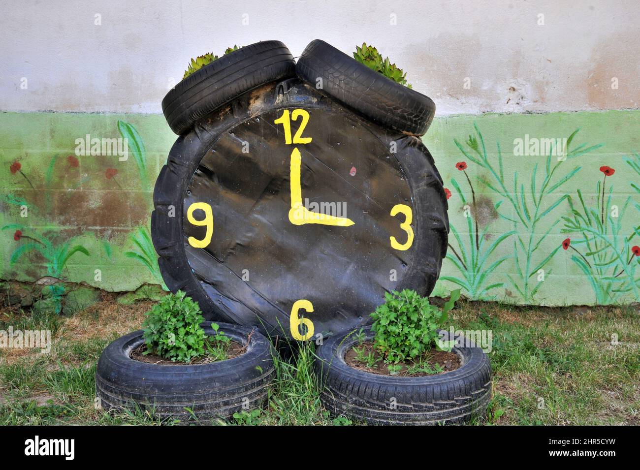 drawn alarm clock on big tractor tire Stock Photo - Alamy