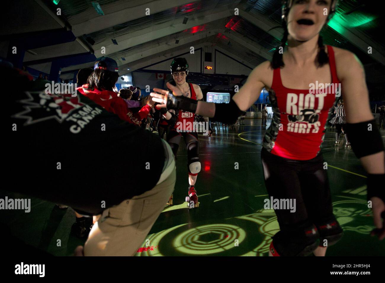 A fan sticks his bum out to be slapped by members of the Riot Girls ...