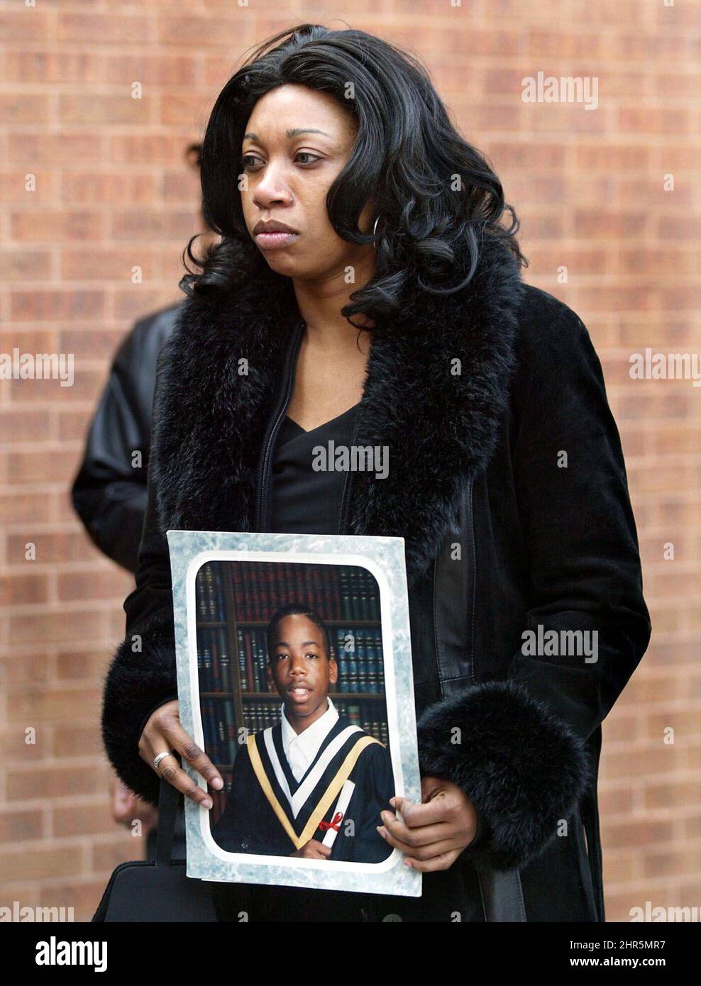PA PHOTOS/CP - UK USE ONLY: Carol Roache holds a portrait of her slain ...