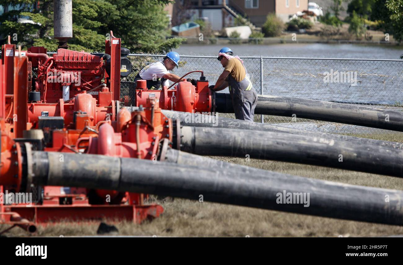 Workers man one of several large pumps as they drain a large area of ...