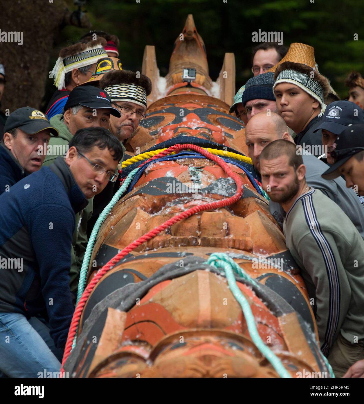 The Gwaii Haanas legacy totem pole is lifted and pushed into a hole ...