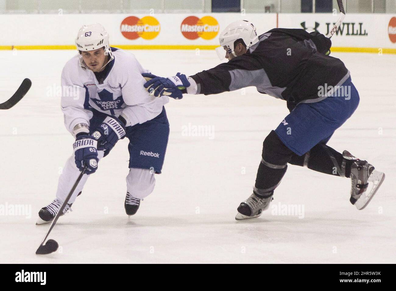 Toronto Maple Leafs Dave Bolland (left) takes the puck past Dylan Yeo ...