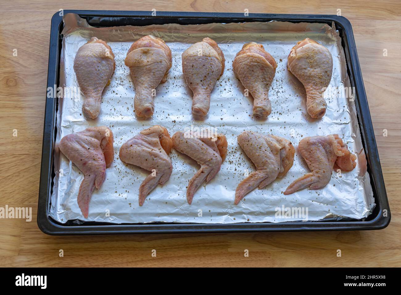 Raw chicken legs and wings lined in a row Stock Photo - Alamy